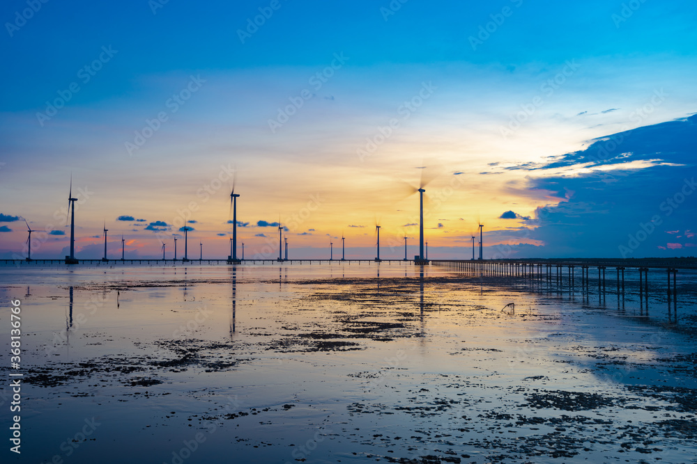 Wind turbines generating renewable energy, morning beautiful sunrise ...