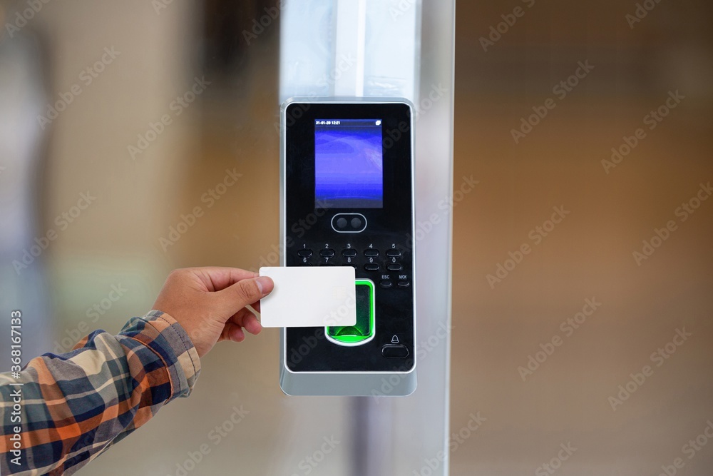 hand holding keycard to access door security systems of lobby interior ...