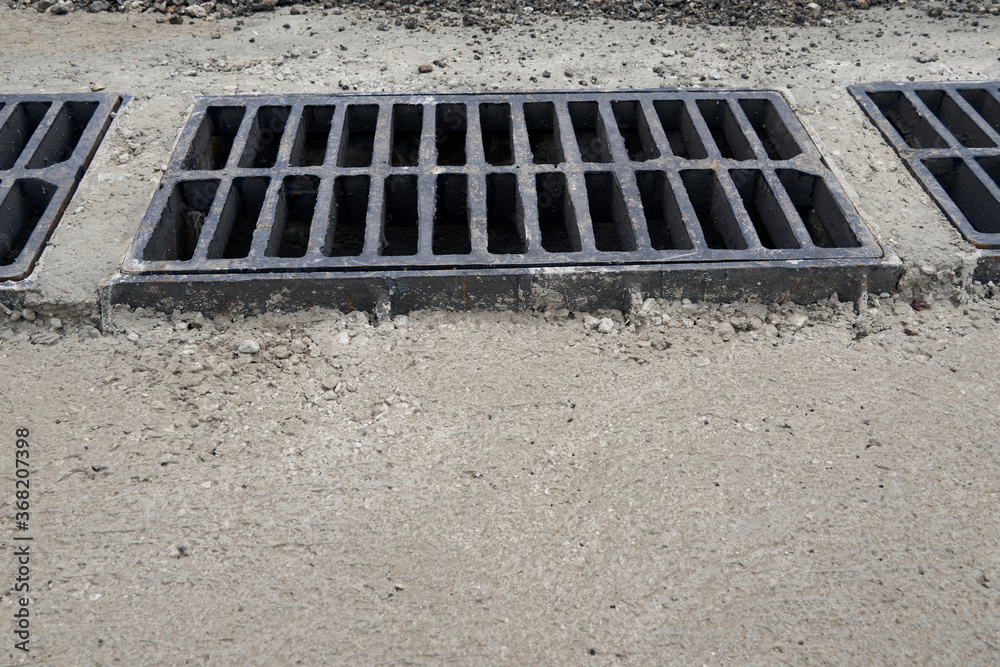 New rainwater grate on the road or sidewalk, installation in concrete ...