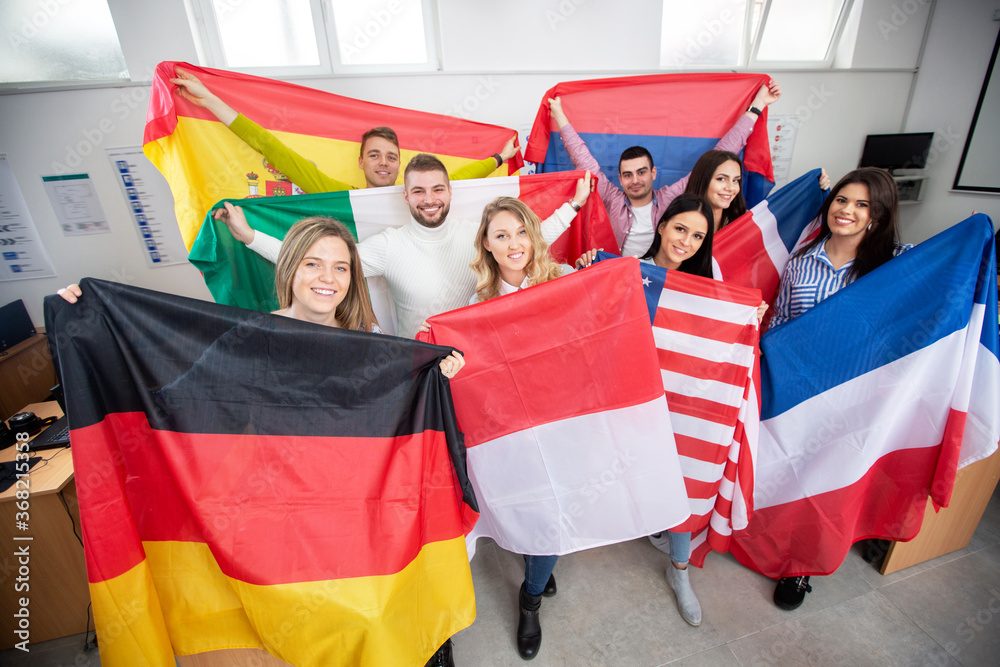 Students holding various flags of different countries in the classroom ...