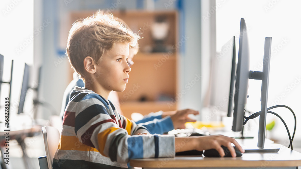 Elementary School Computer Science Classroom: Cute Little Boy Uses ...