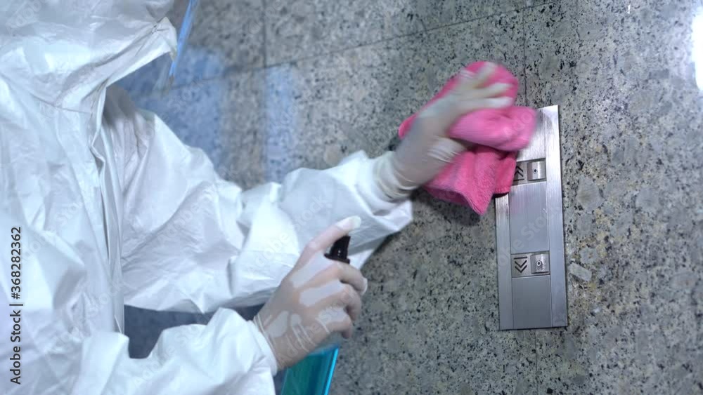 Specialist wearing ppe suit using alcohol sanitizer spray to cleaning ...