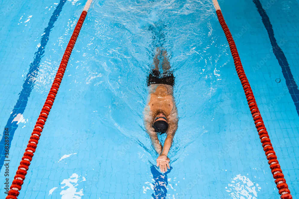Swimmer floating in the swimming pool, top view. Relaxing bode on blue ...
