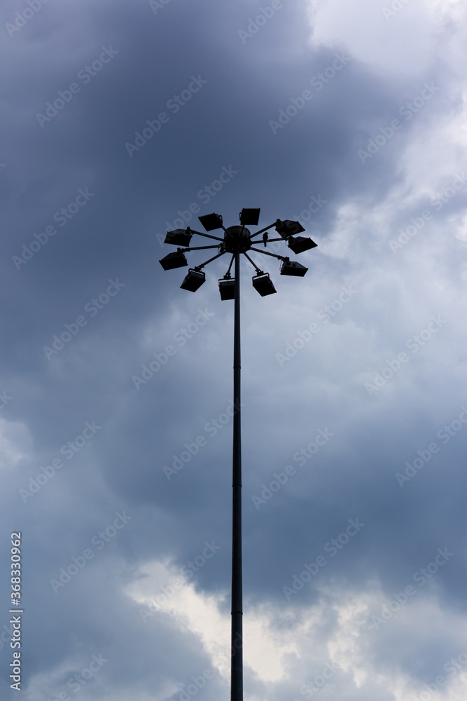 Modern lighting mast with lanterns against the dark sky with a sitting ...