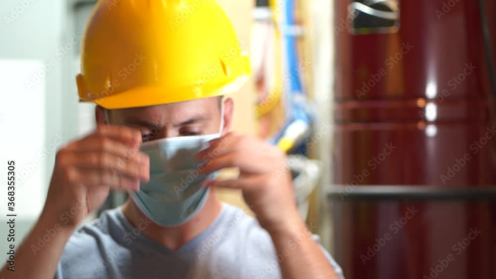 Man putting on mask at work on construction site and wearing safety ...