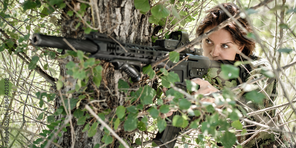 Beautiful and attractive woman soldier shooting with rifle machine gun ...