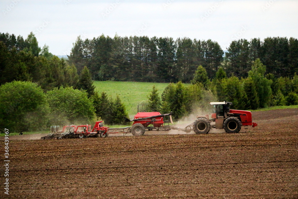 large tractor with plow plows field before spring sowing of crops ...