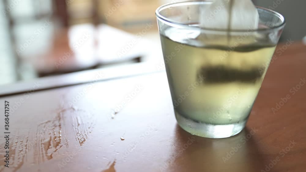 Preparation of a cold herbal tea. Close up shot of a glass full of cold ...
