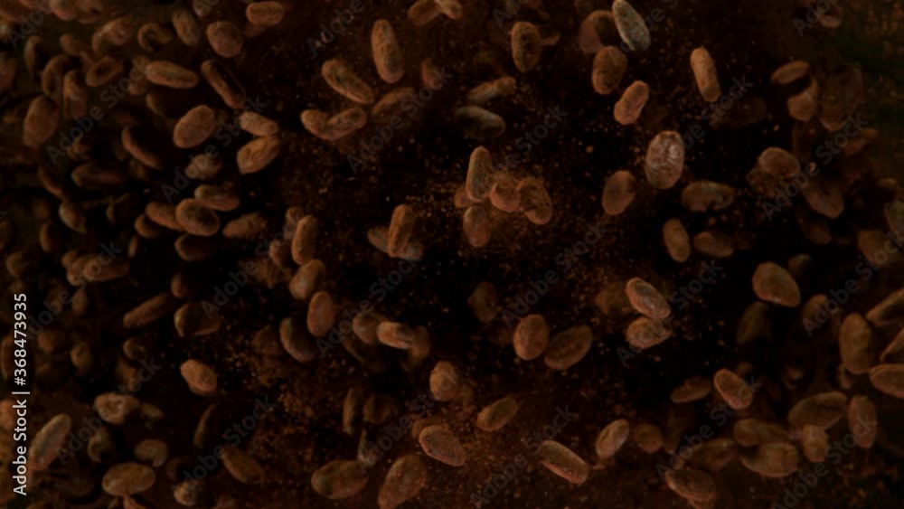 Super slow motion of exploding roasted cocoa beans up in the air ...