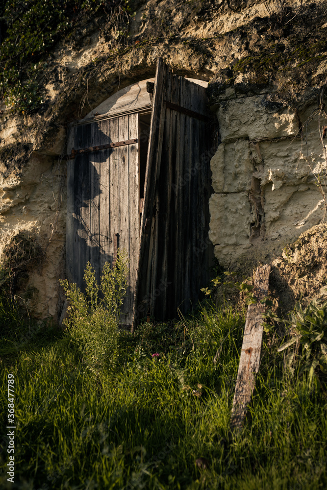 Old door opening to a cave built into the rock Stock Photo | Adobe Stock