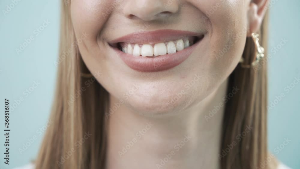 Smiling female mouth licking with tongue natural white teeth, selective ...