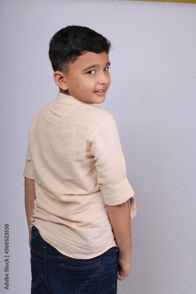 Cute and smart Indian boy displaying pose. Its a front facing photo ...