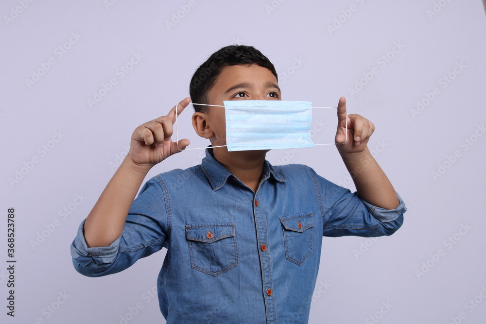 Cute Indian boy showing surgical mask. Isolated on white background ...