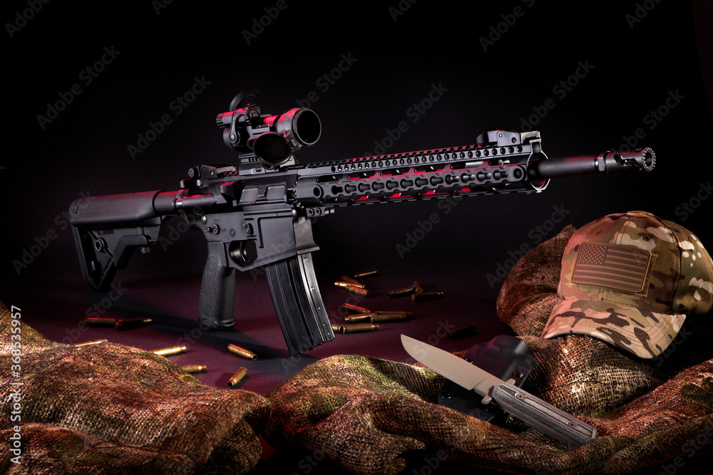 Dramatic studio lighting of an AR-15 Rifle with rounds, a knife and ...
