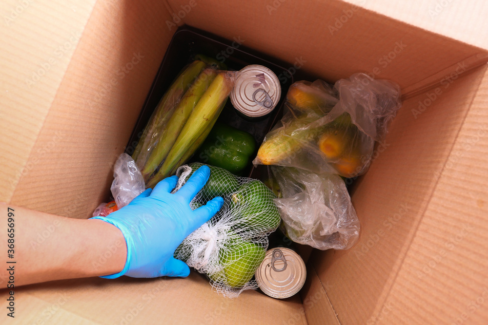 Door delivery of goods. Order picker packing foods in a cardboard boxes ...