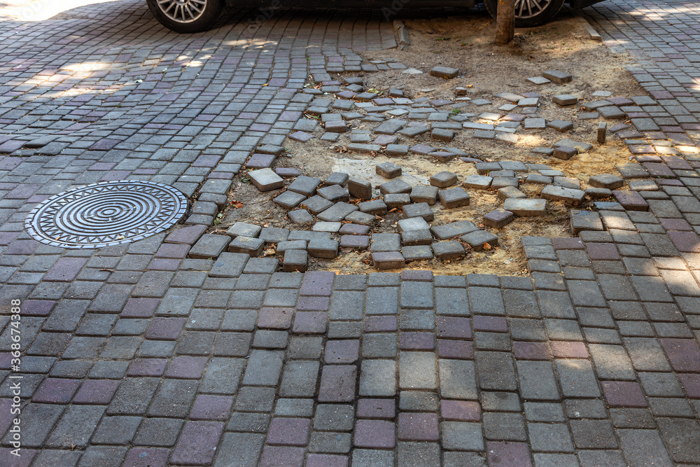 The damaged asphalt road with potholes caused by freeze-thaw cycles ...