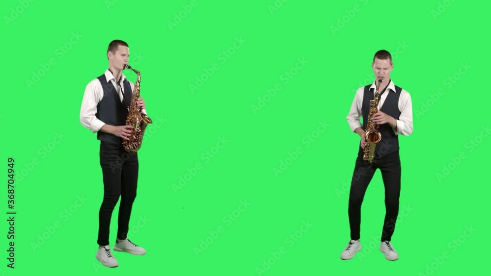 Portrait stylish young guy plays at saxophone on a green screen in the ...