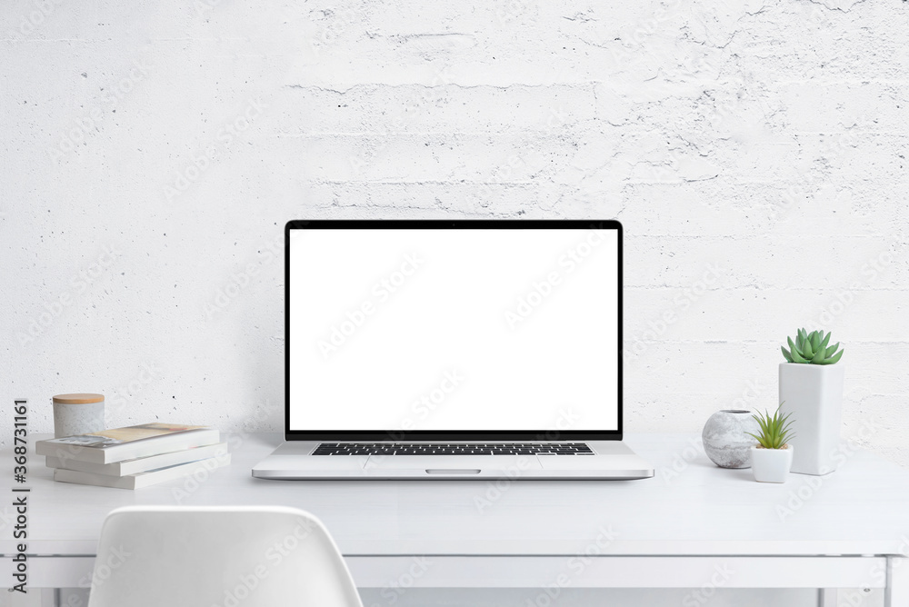 Modern laptop with isolated screen for mockup on office desk. Plants ...