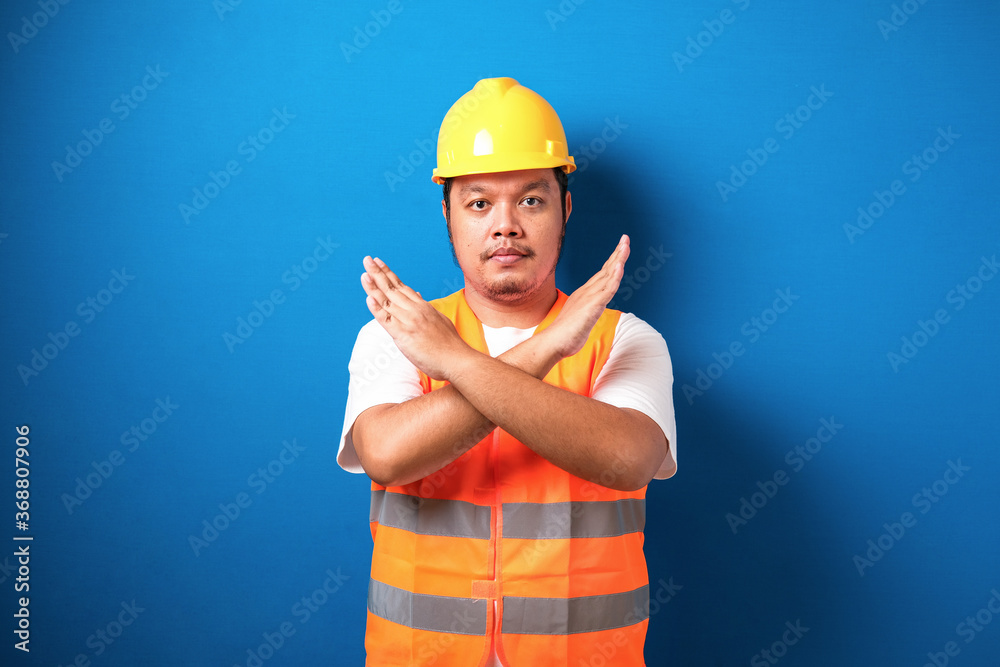 Fat asian workman wearing orange safety vest and yellow helmet making ...
