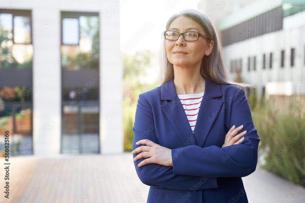 Portrait of confident mature business woman wearing eyeglasses and ...