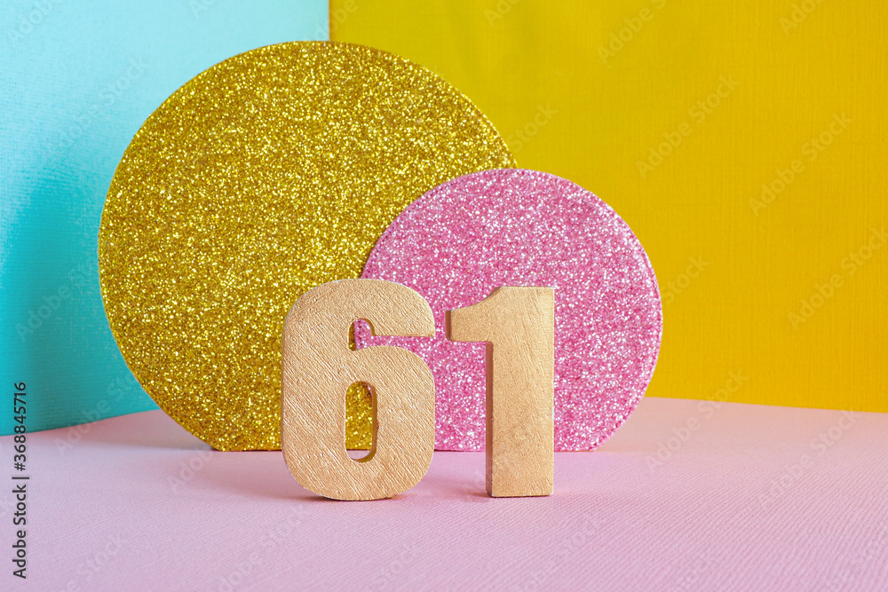 golden number "61" on a multicolored blue-yellow-pink background and ...