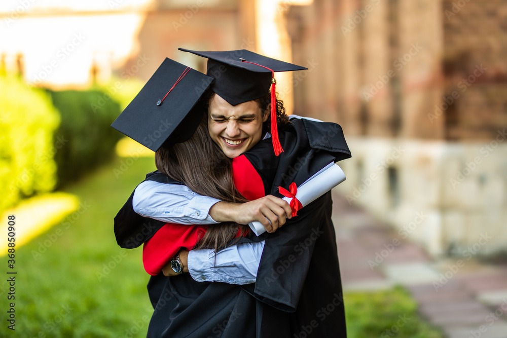 Hugging her friend,Student in mortarboard feeling hugging her friend ...