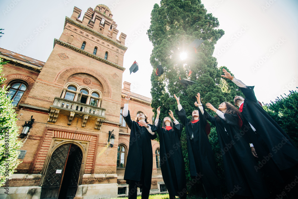 Successful five students with congratulations together throwing ...