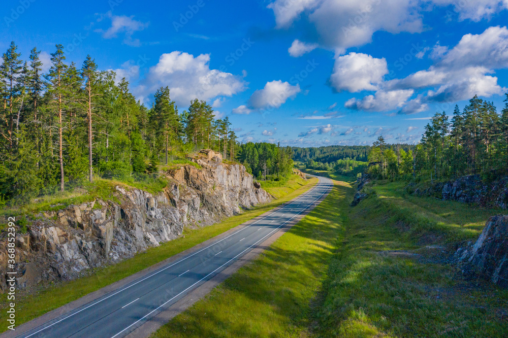 Highway among rocks and pines. Journey. A deserted country road. The ...