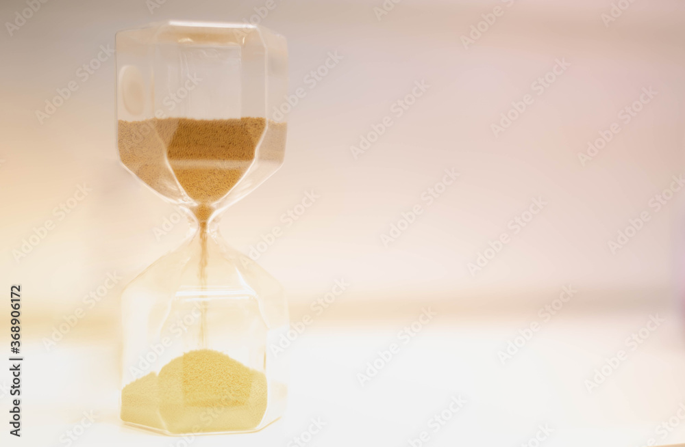 Sand running through the hourglass measuring the passing time in a ...