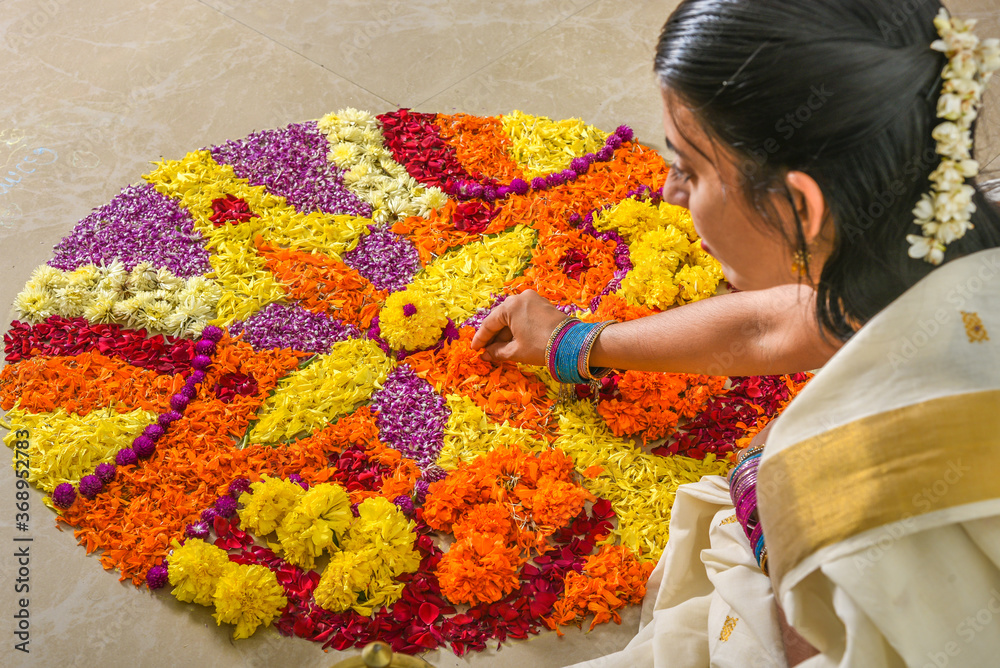 Kerala Onam festival, Indian woman putting Flower bed or Pookalam ...