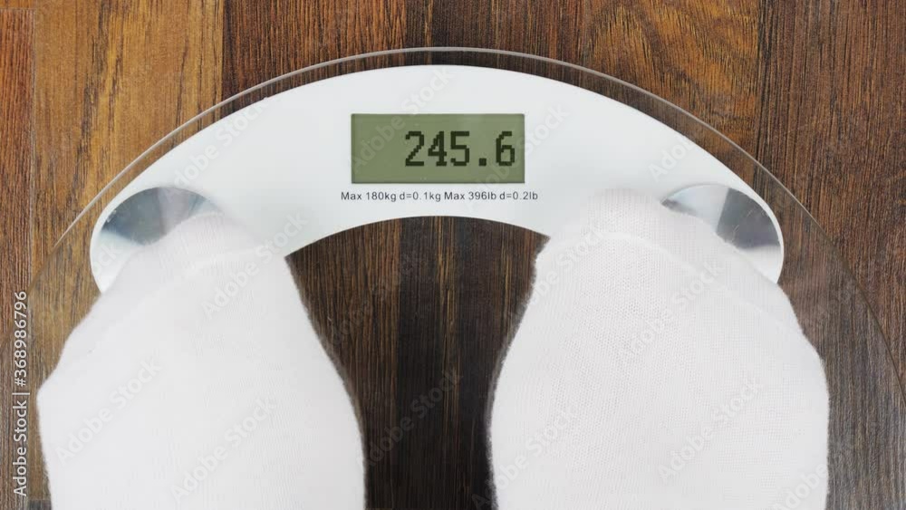 Overweight on bathroom scales. Digital display with an inscription ...
