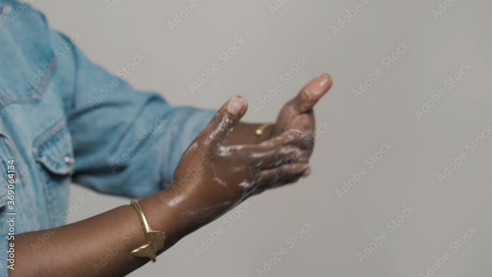 Close up of Black women washing hands with soap on light brown ...