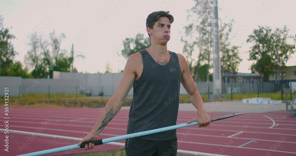 Sportsman doing javelin throw on athletic ground. Male athlete throwing ...