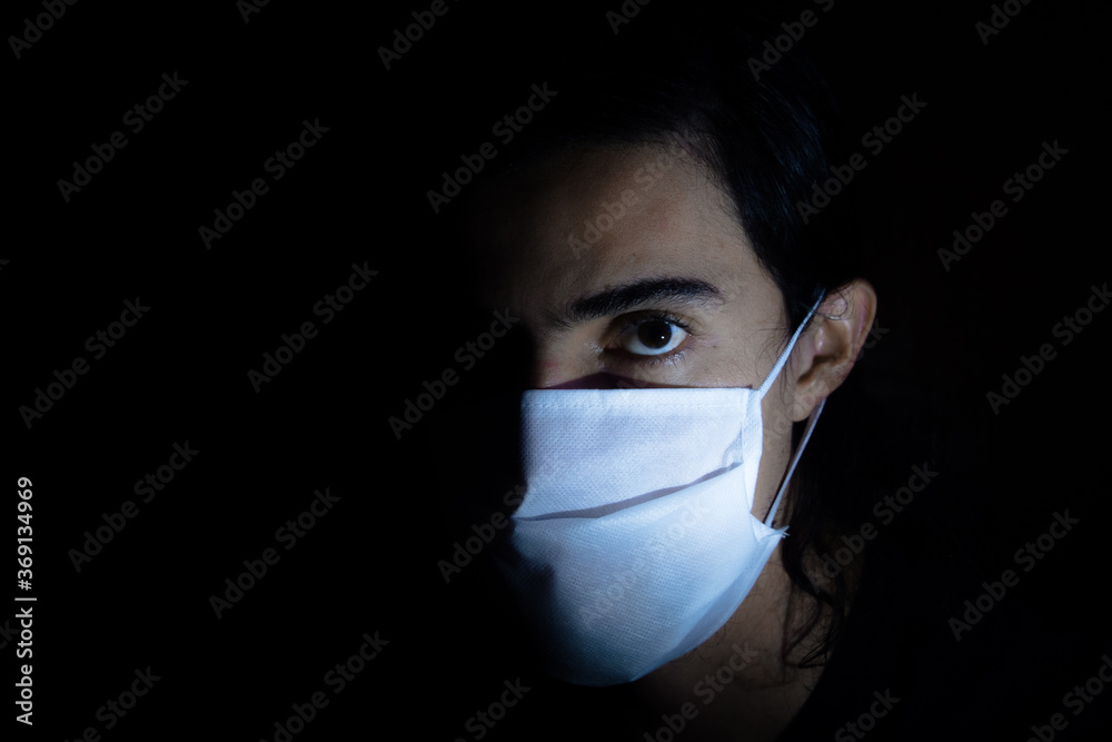 Profile portrait of a man with a disposable white face mask looking ...