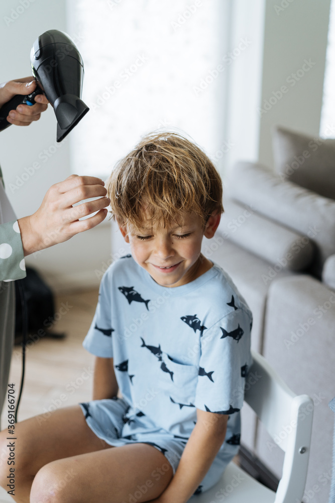 Cute boy smiling during hairstyling at home Stock Photo | Adobe Stock