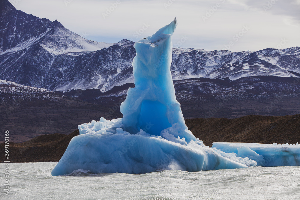 Beautiful turquoise iceberg with a long tall ice pillar floating on the ...