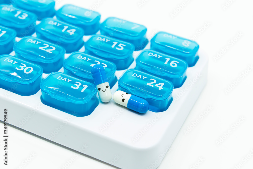 Close up of Blue smiling face capsule medicine on the monthly pill ...