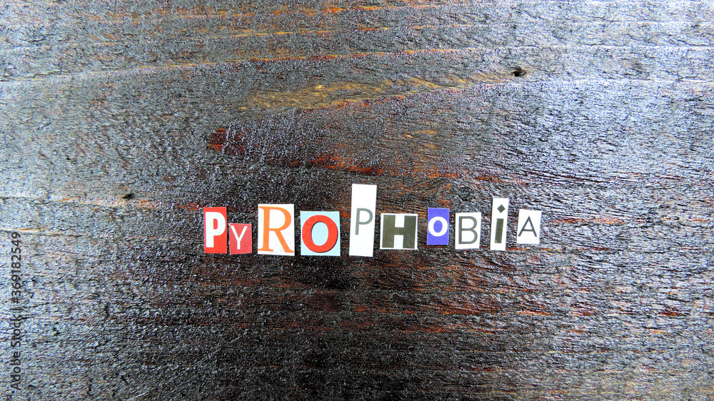 Pyrophobia word from paper letters on wooden boards, fear of fire and ...