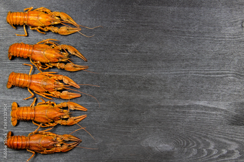 Five red boiled crawfish on the dark wood background. Cooking food ...