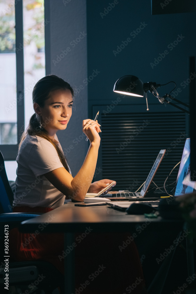 the girl works at the computer is concentrated on work in the office ...
