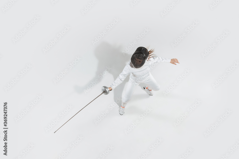 First. Teen girl in fencing costume with sword in hand on white ...