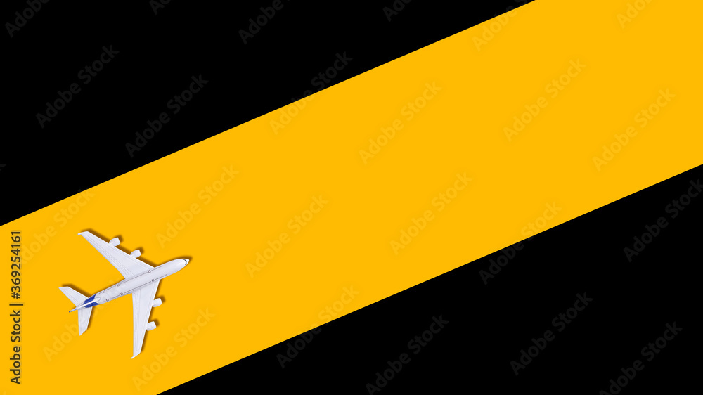 Plane on a yellow-black background. Flat lay with copy space and top ...