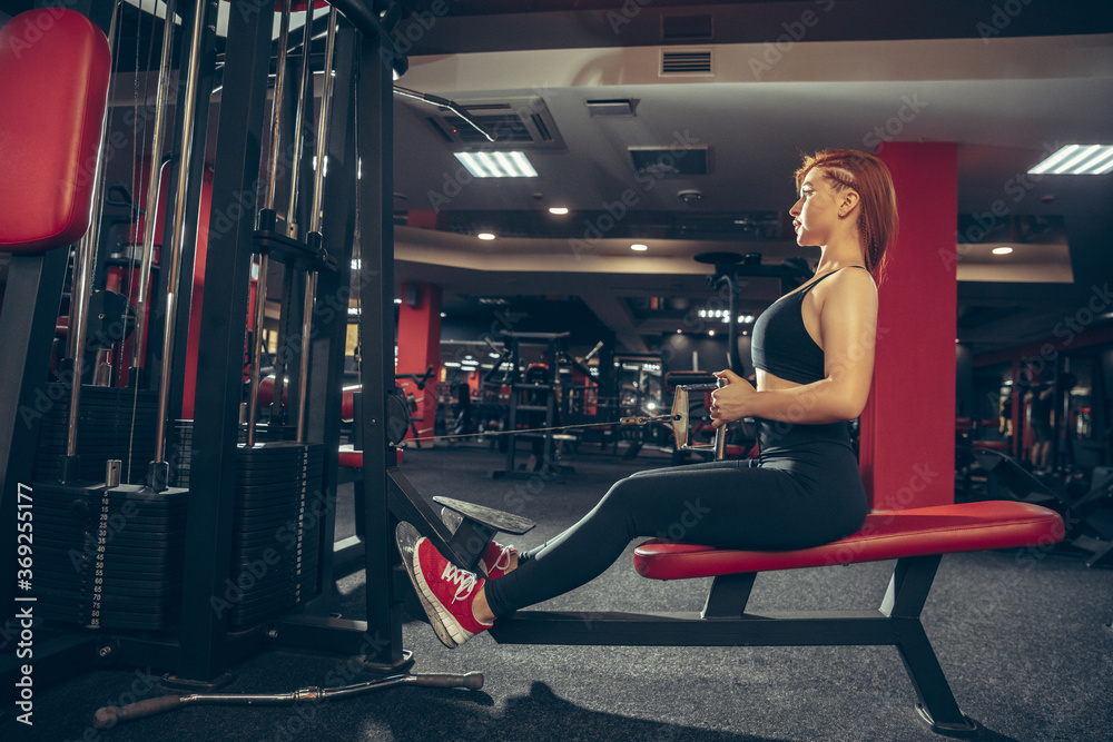 Position. Young muscular caucasian woman in gym with equipment ...