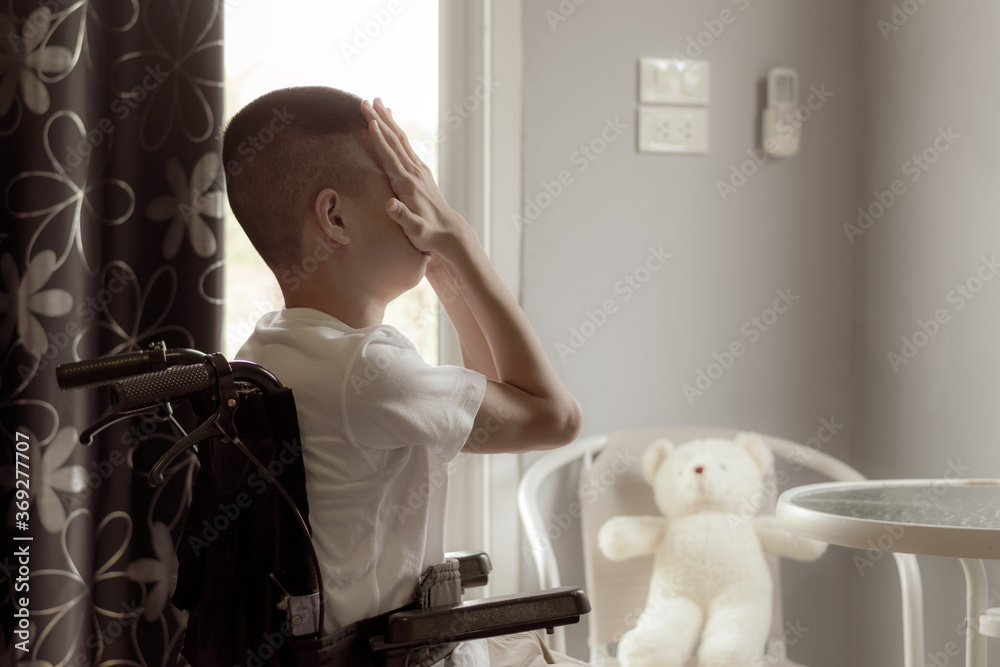 Asian special child on wheelchair with his good friend is teddy bear ...