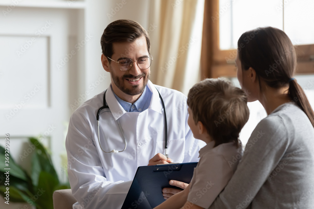 Smiling male pediatrician in white medical uniform holding clipboard ...