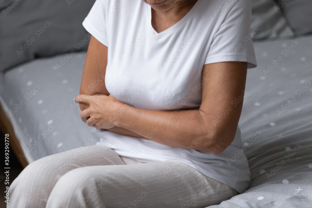 Naklejka elderly woman woke up hunched sit on bed hug herself suffers ...