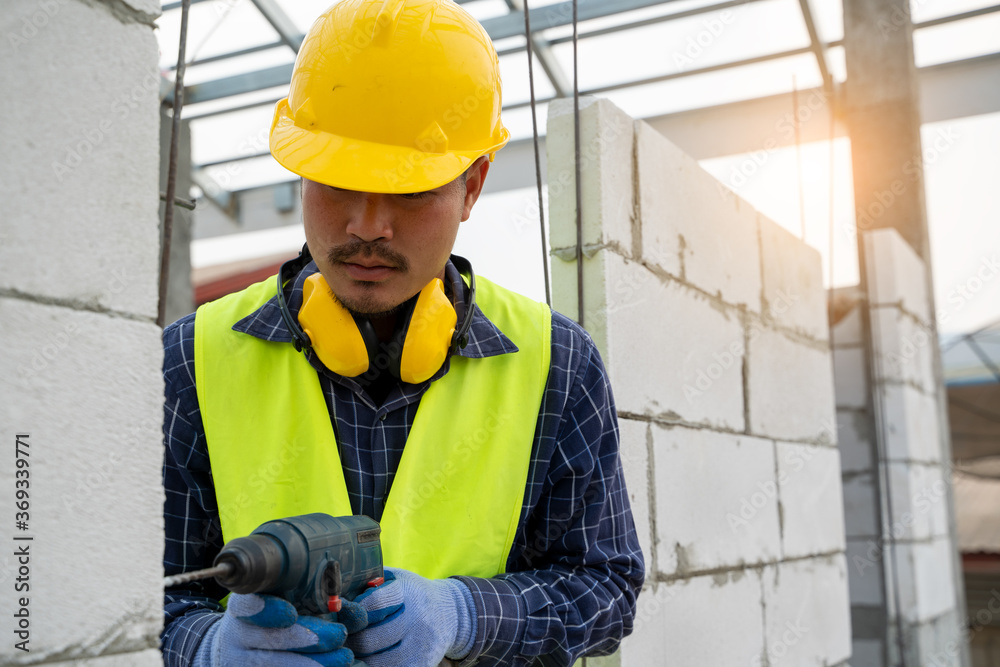 Construction workers using a drilling power tool for drilling aerated ...