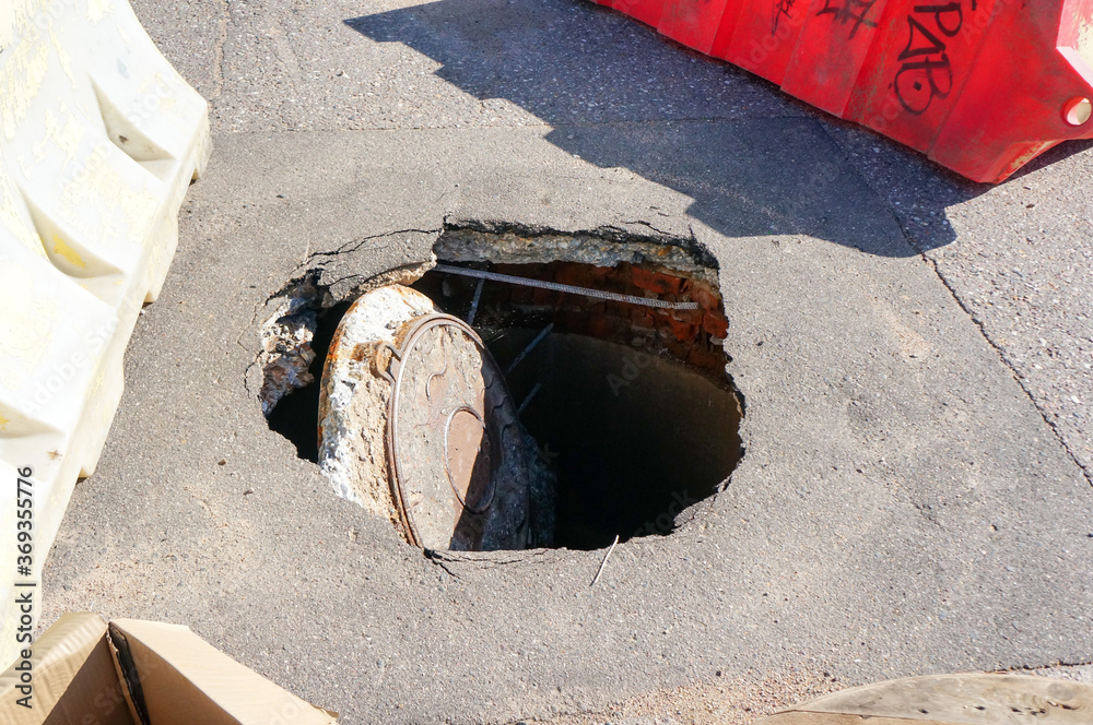 Deep sinkhole on a street city and orange traffic cone. Dangerous hole ...