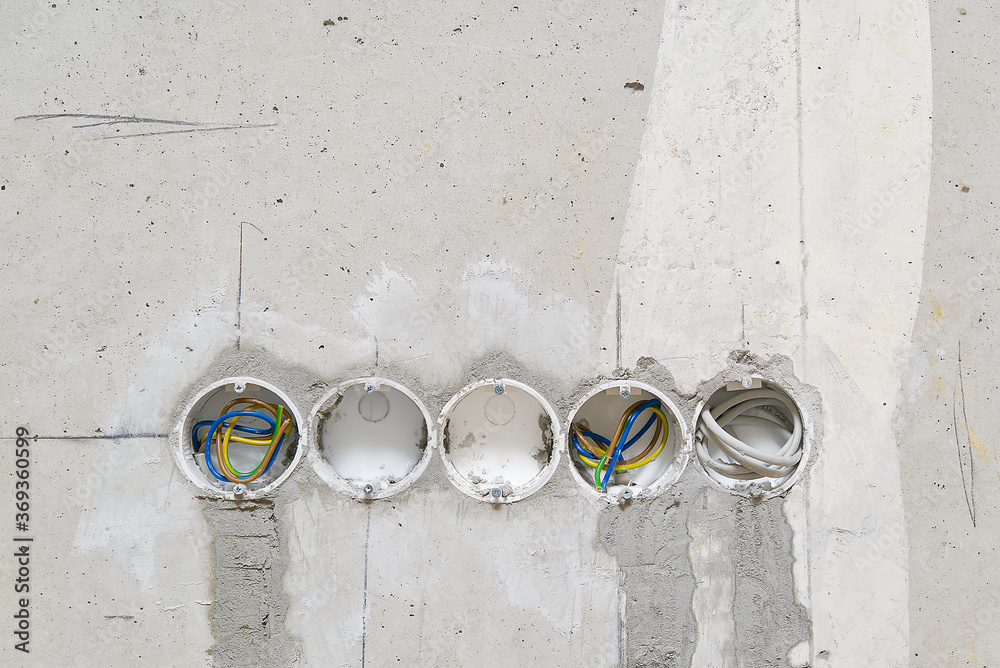 Holes in a concrete wall for installing plastic boxes under sockets ...