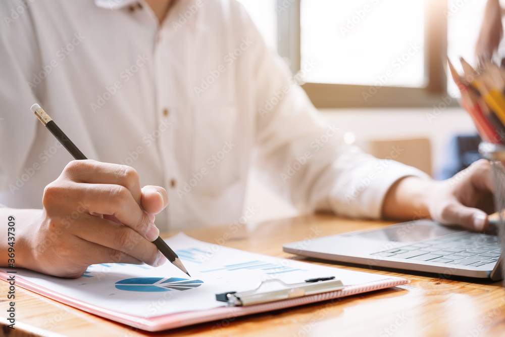 Foto de Businessman pen pointing turnover with graph chart report and ...